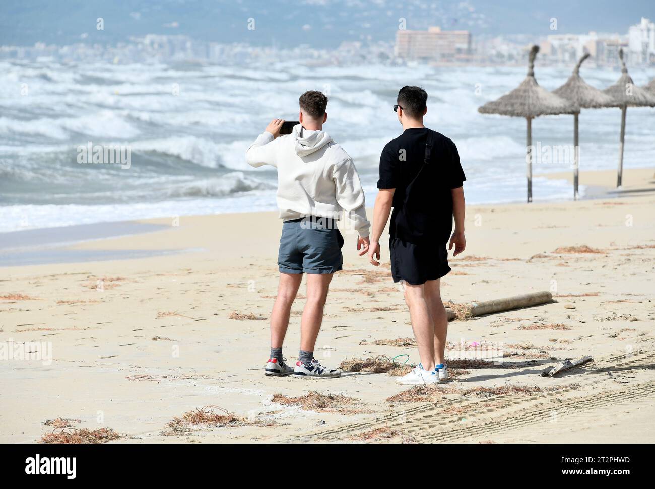 Images of bad weather on the beach of Palma in Mallorca. Tourists walk ...