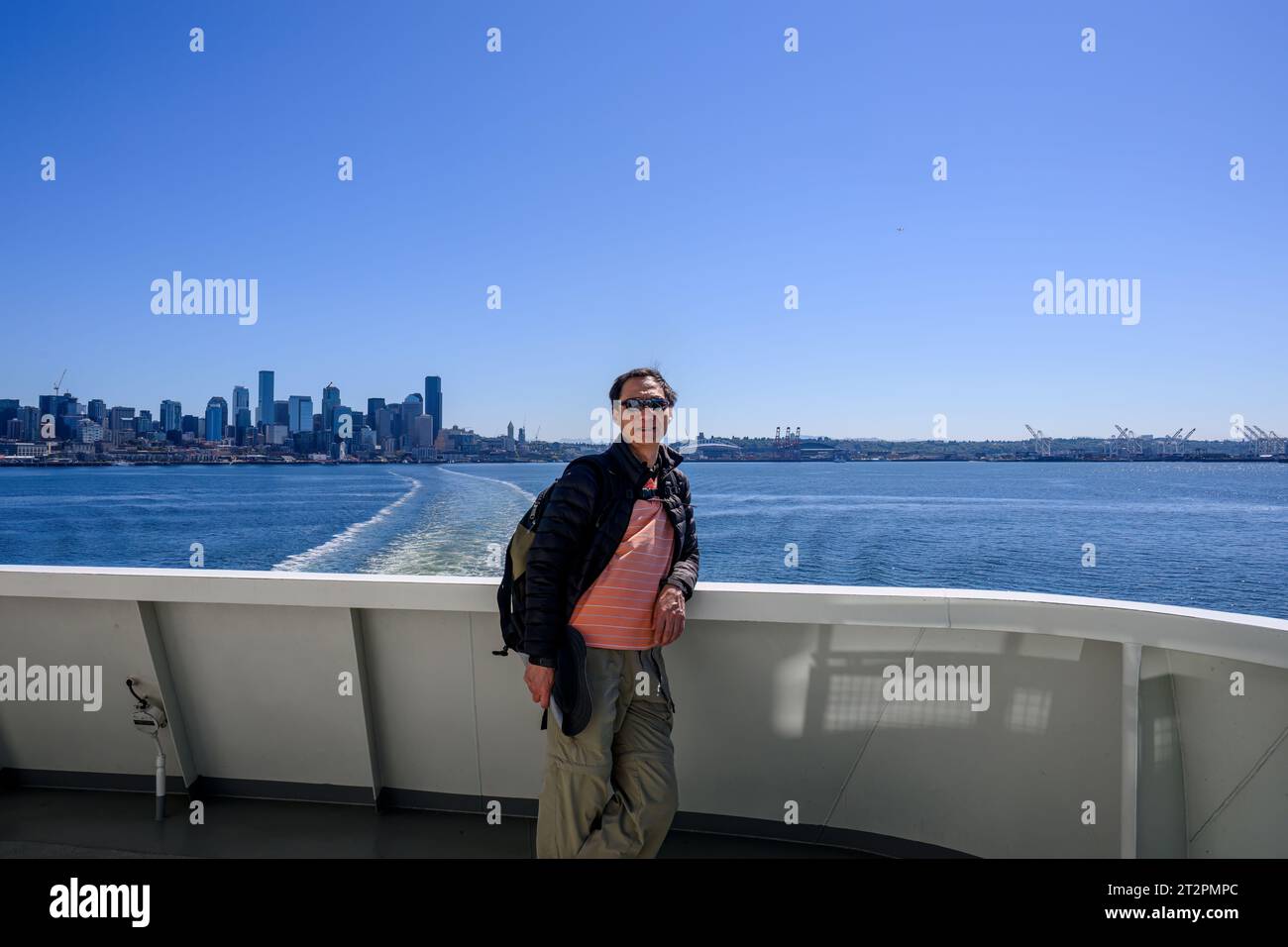 Tourist posing for phones on the ferry at Elliott Bay. Seattle skyline ...
