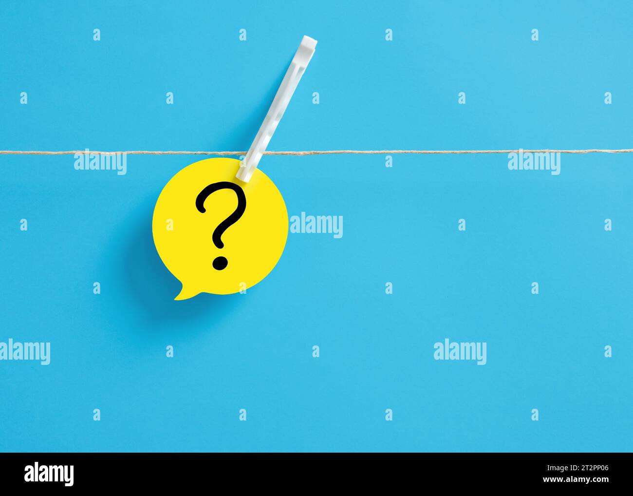 Question mark symbol on a speech bubble hanging on clothesline with a ...