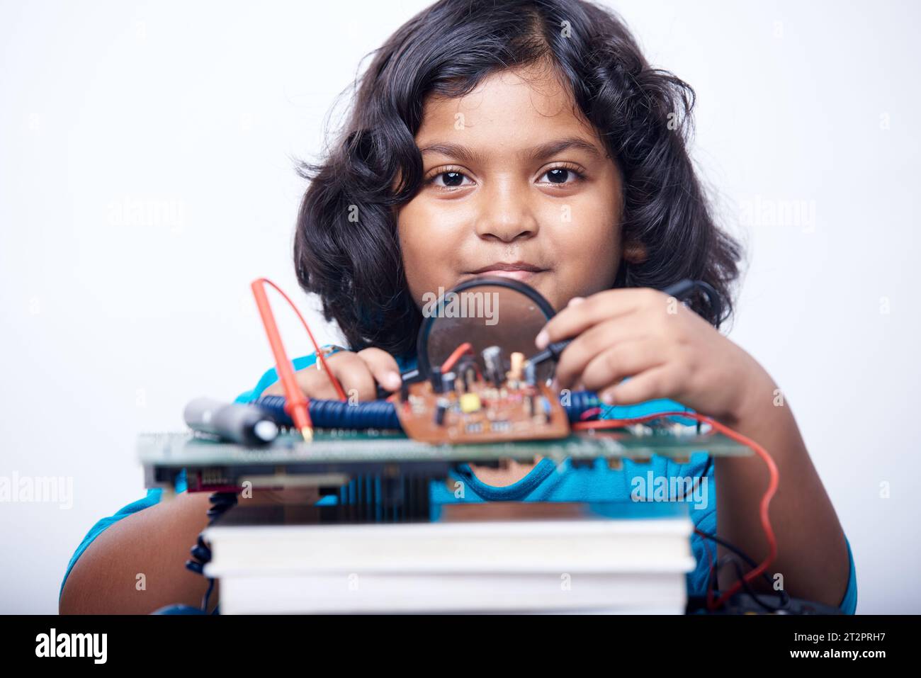 Student girl using magnifying glass working on a computer motherboard ...