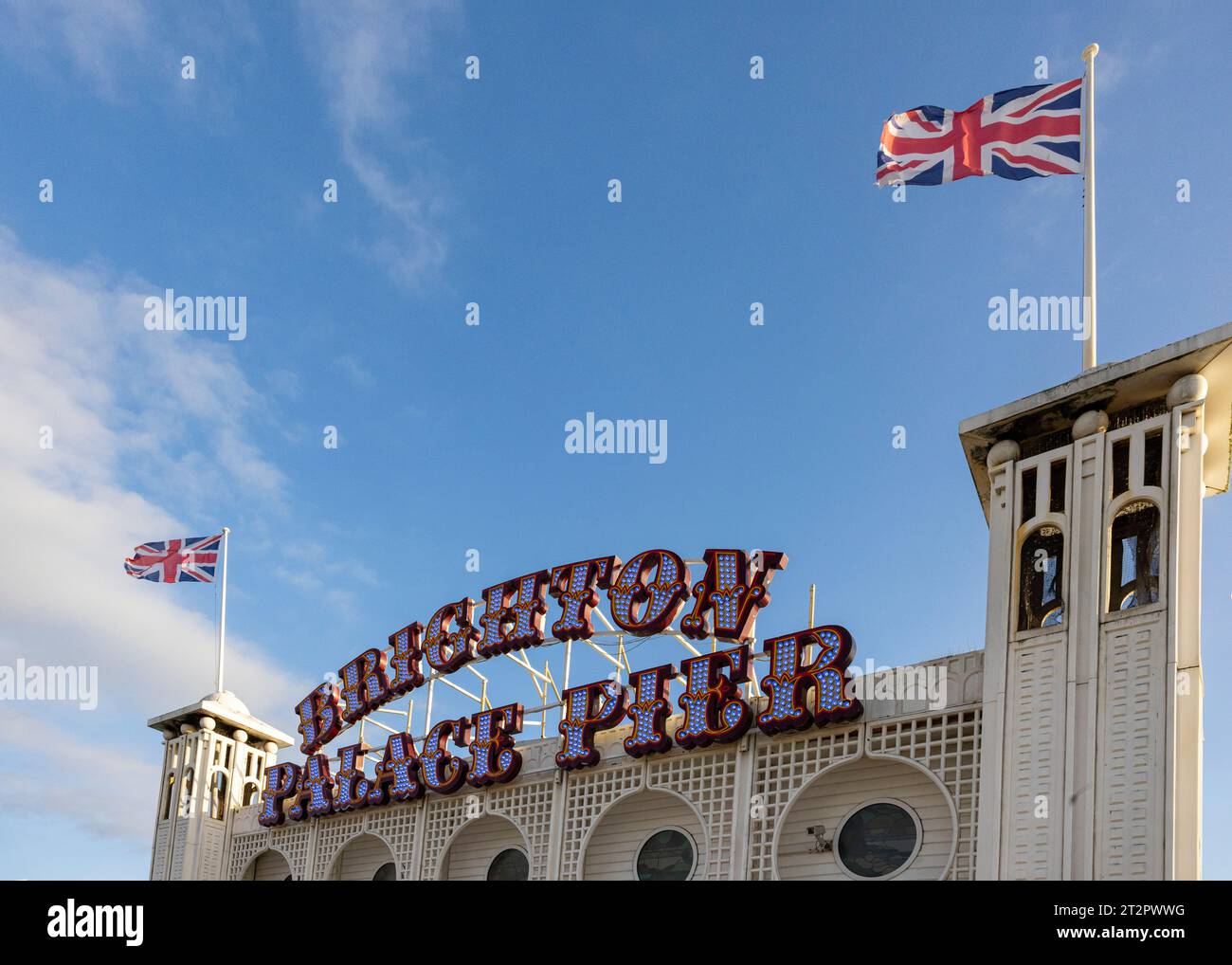 The iconic neon sign with union flags flying above Brighton Palace Pier ...