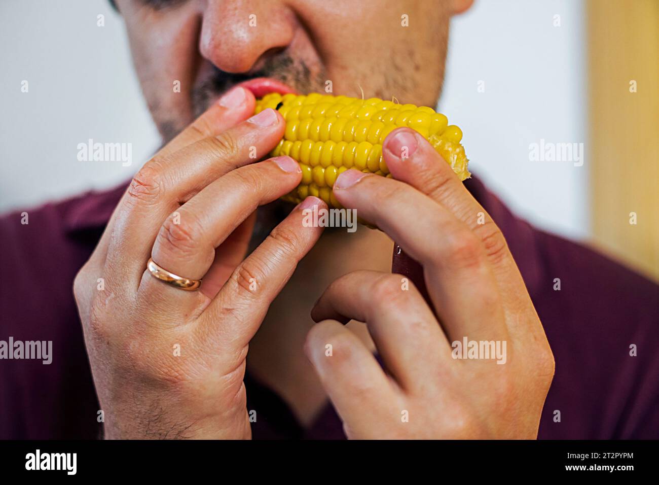 man eating sweet corn with both hands Stock Photo - Alamy