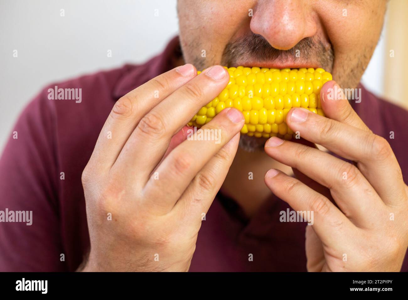 man eating sweet corn with both hands Stock Photo - Alamy