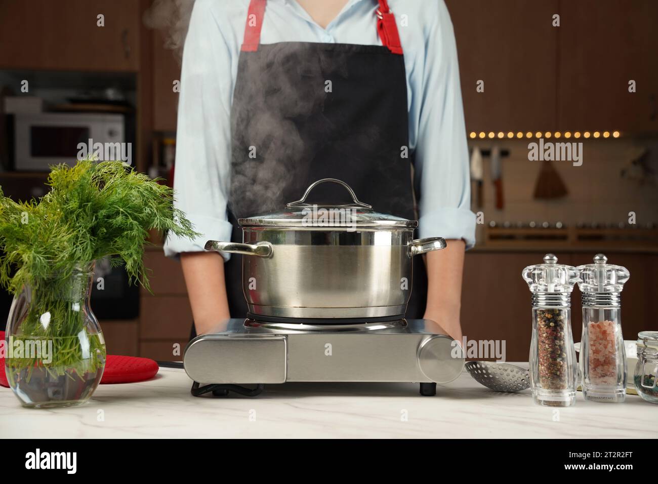 Steel cooking pan on electric hob with boiling water Stock Photo - Alamy