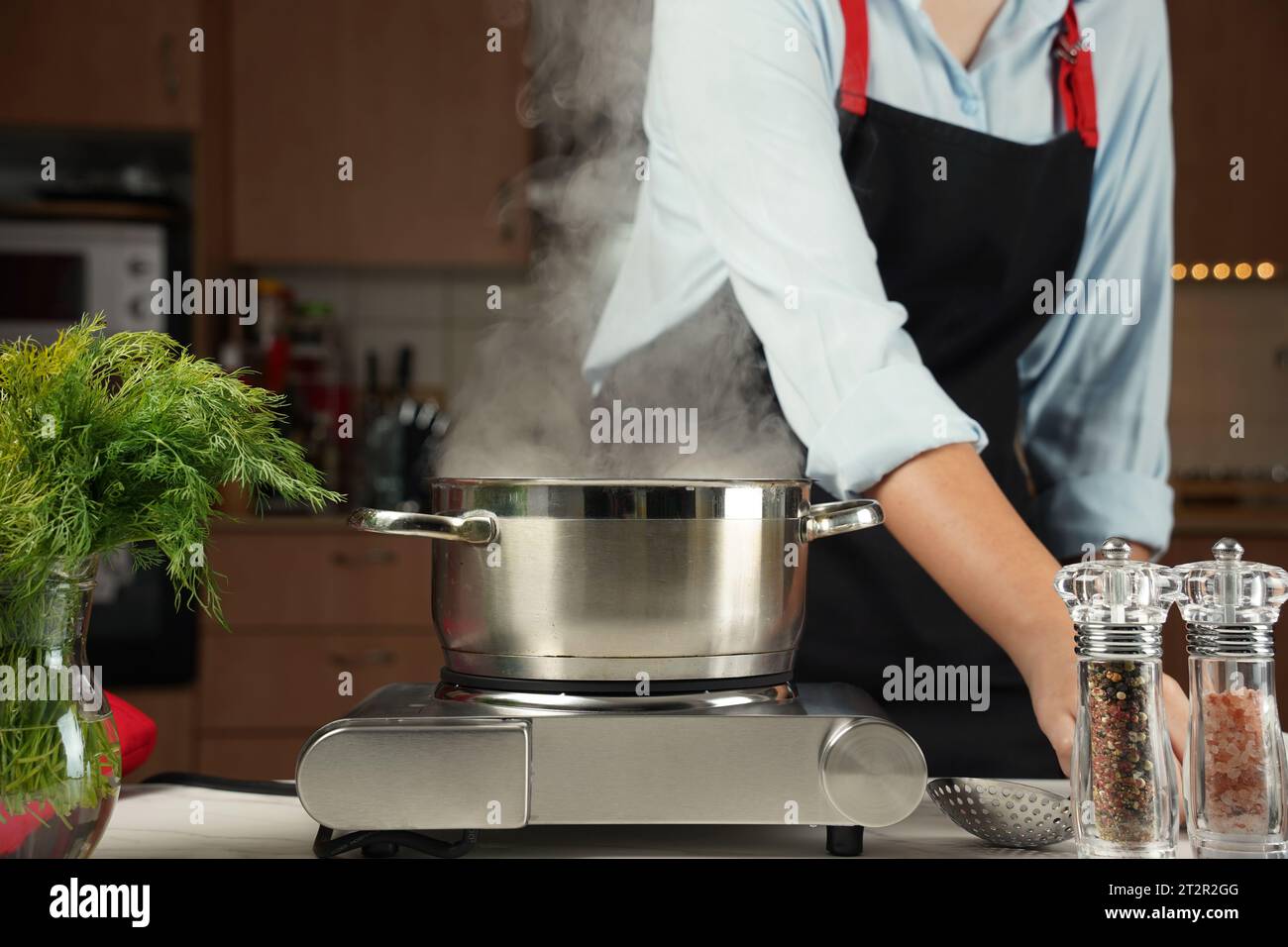 Steel cooking pan on electric hob with boiling water Stock Photo - Alamy
