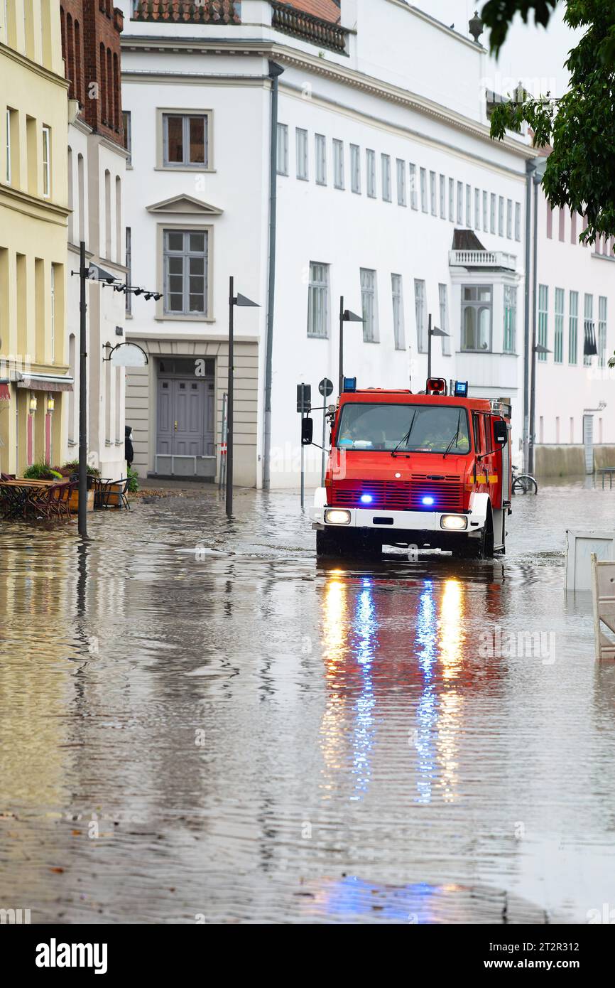 Fire truck drives through the flooded streets of the old town of Lubeck to warn residents during ...