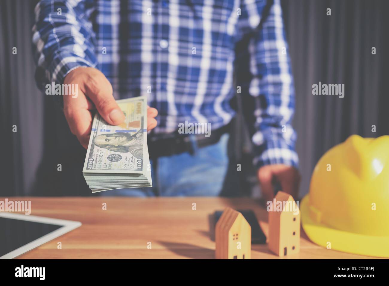 Engineer sitting and counting dollar bills Stock Photo - Alamy