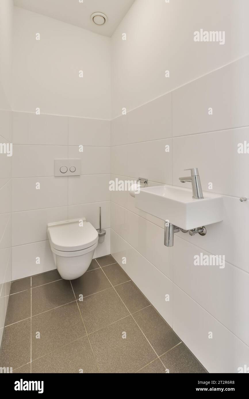 a bathroom with white walls and tile flooring the toilet is on the left ...