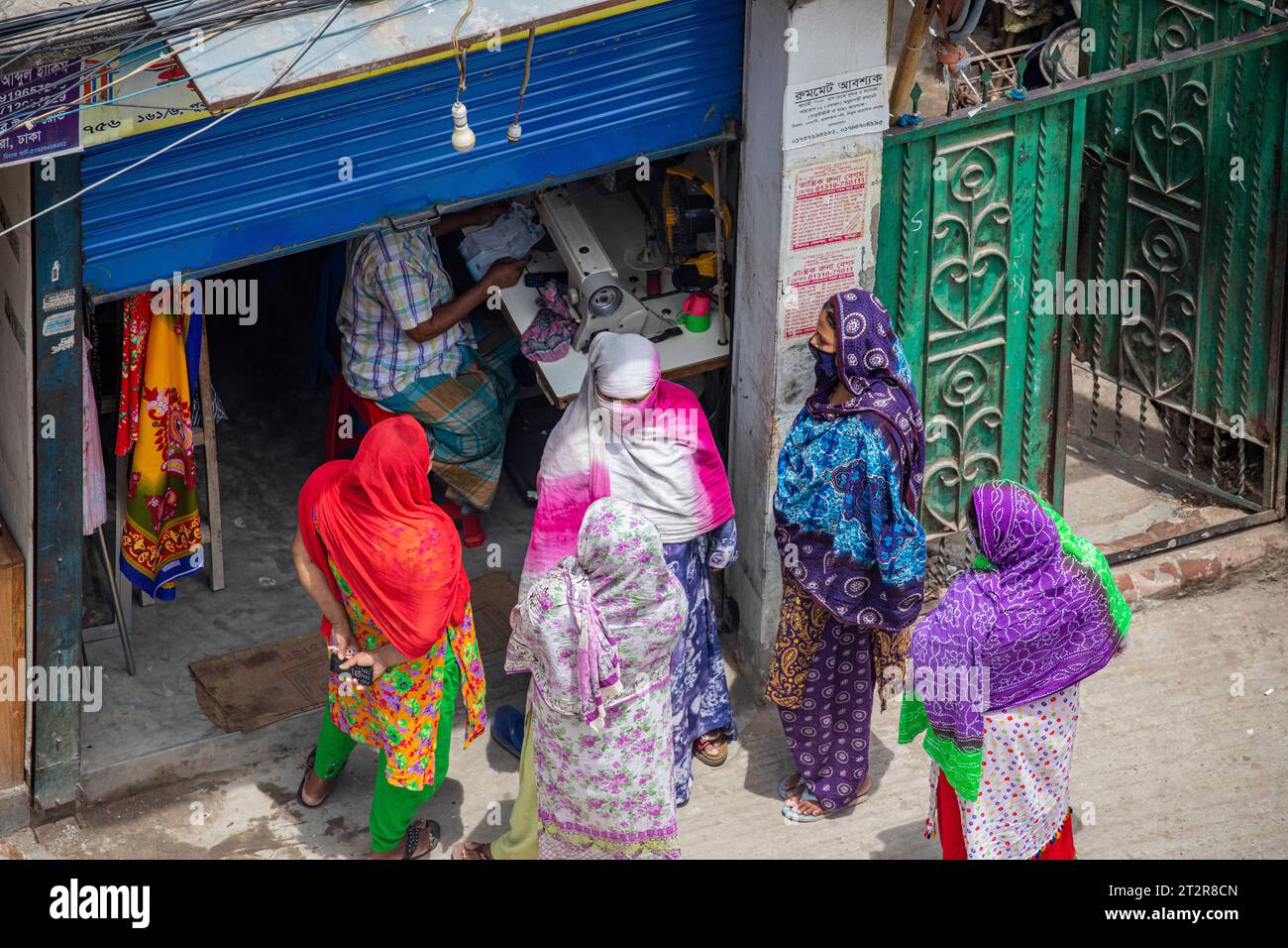 Women gossiping in front of a shop during covid 19 pandemic lockdown, at a street in Dhaka ...