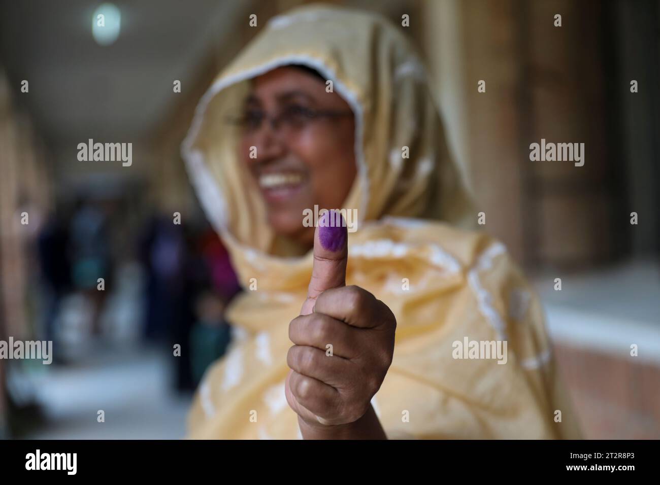 A voter proudly displays the indelible ink mark on her thumb after ...