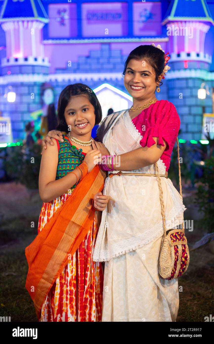 Indian mother and daughter in traditional dress smiling at camera in ...