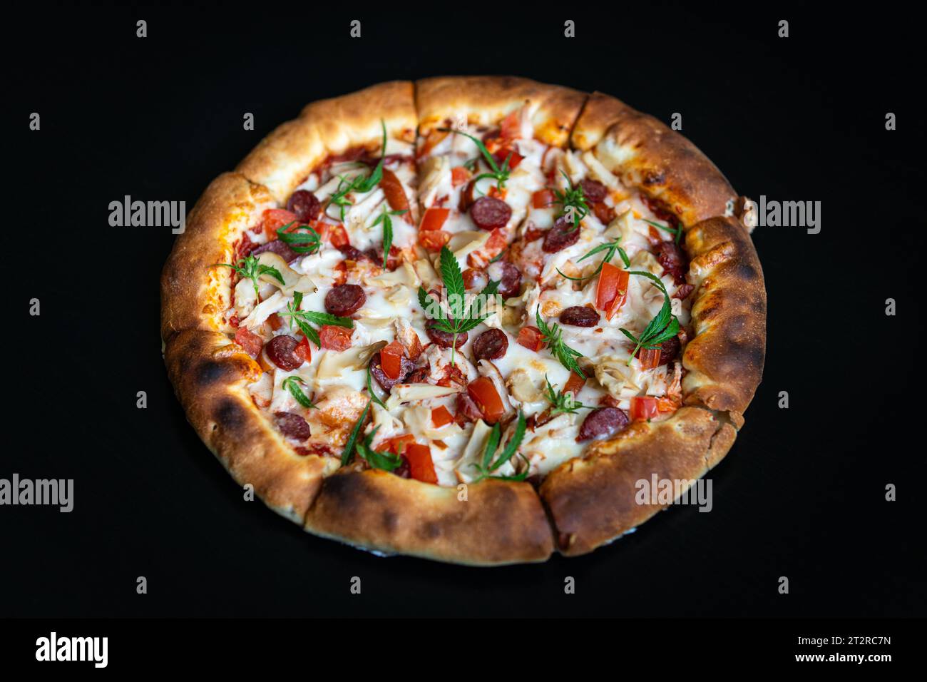 Pizza with marijuana leaves o on a black background. cooking food from ...