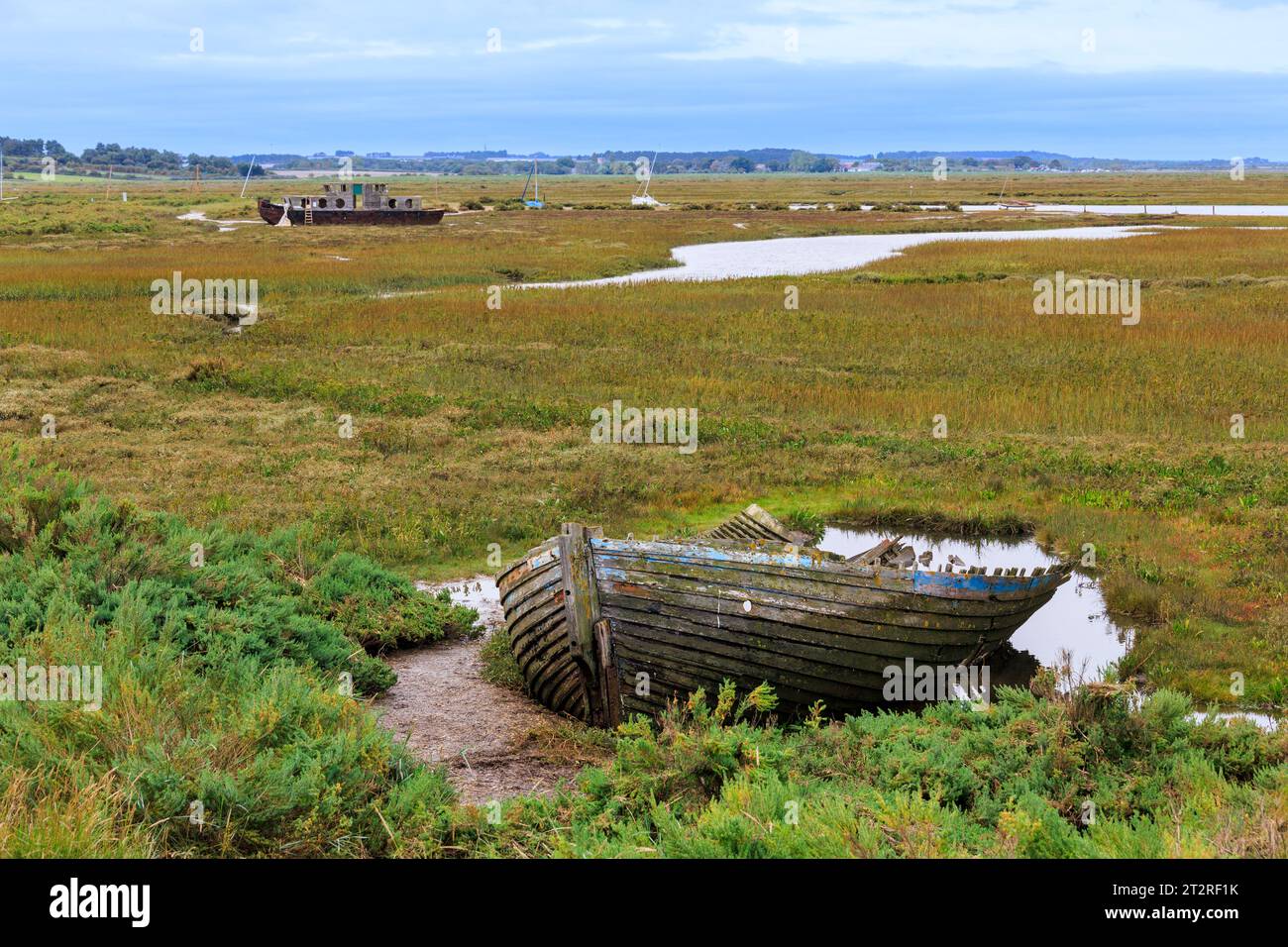 A decaying wooden boat rotting in the Blakeney salt marshes with ...