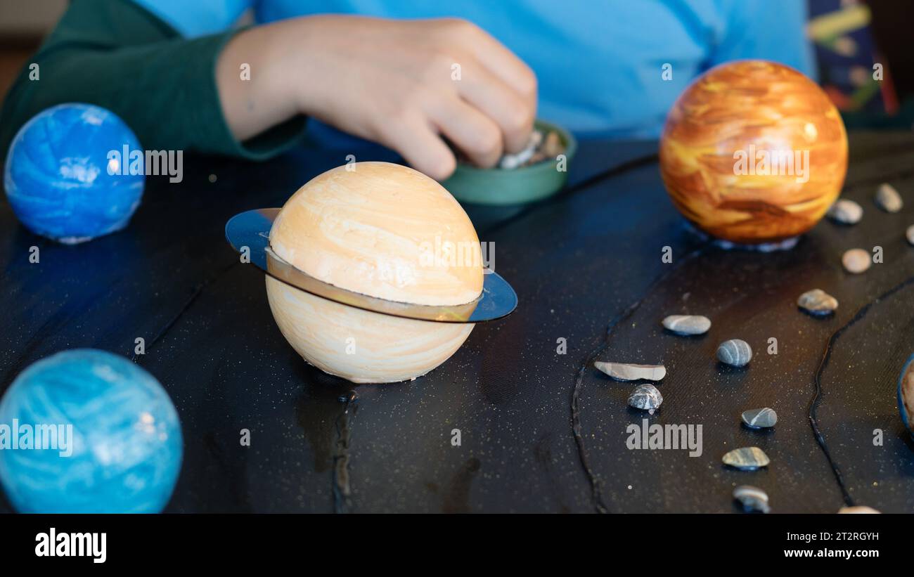 Close-up view of painted planets being assembled for a detailed solar ...