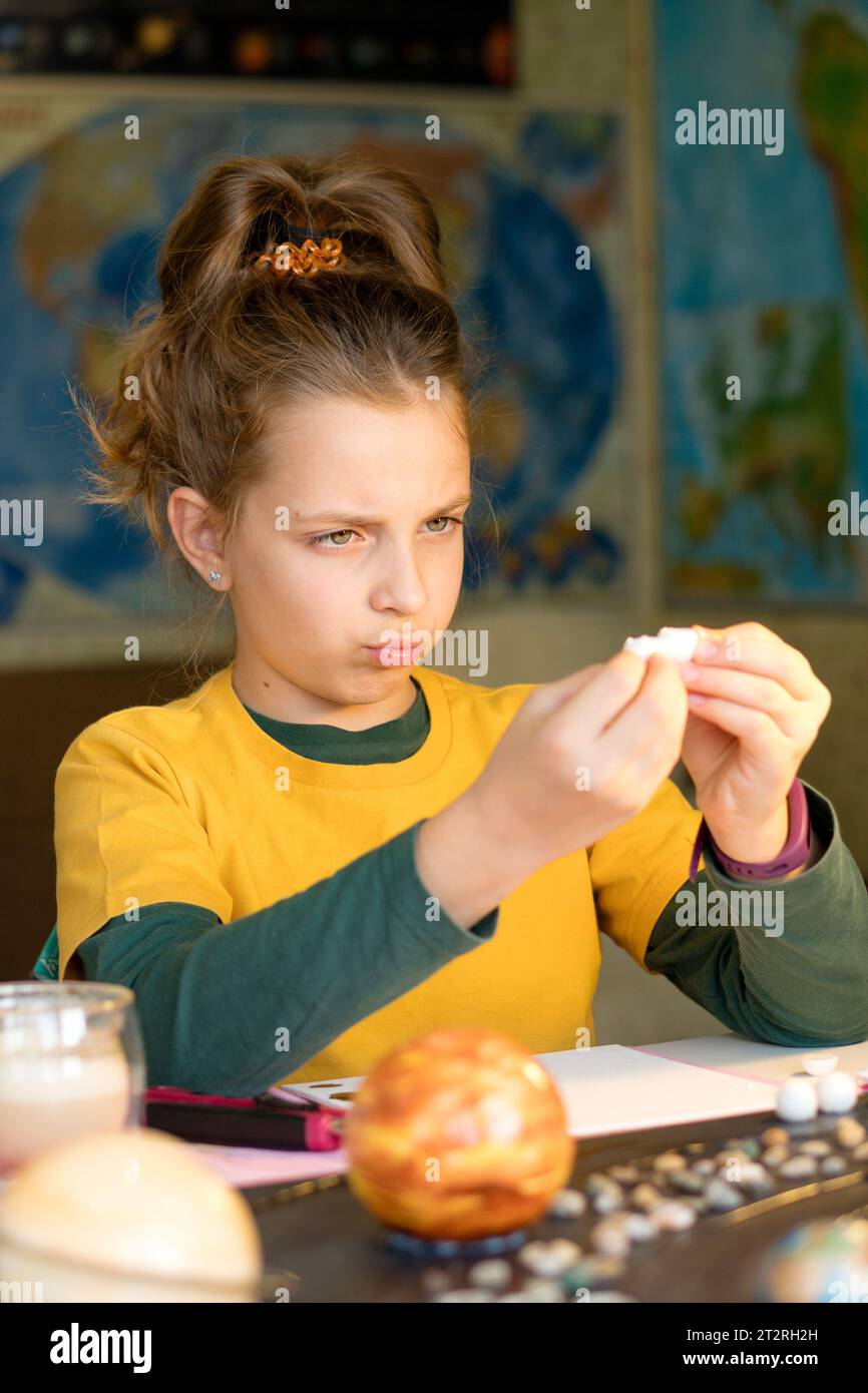 Young girl with a pouty expression, deeply engrossed in assembling a ...
