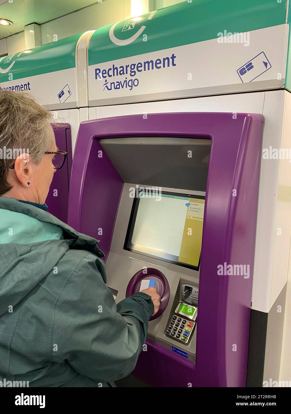 Elderly woman charging her smart card at a charging station for the ...