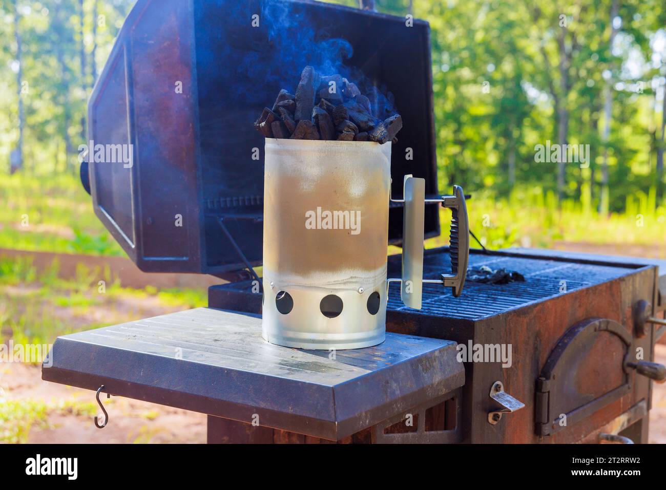 BBQ chimney starter in use to get charcoal ready for grill Stock Photo ...