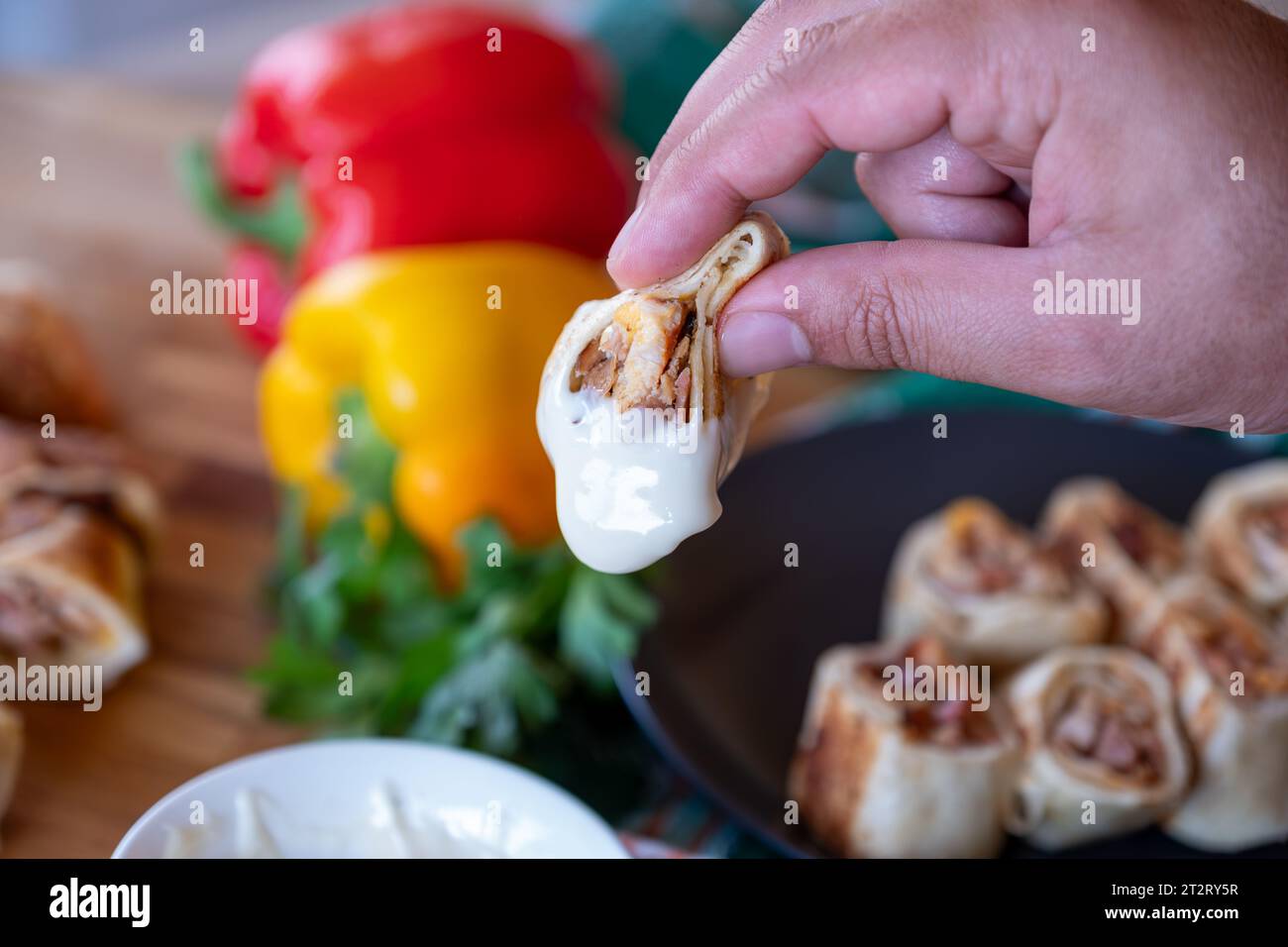 hand holding shawarma piece and dip it in mayonnaise or garlic tahini ...