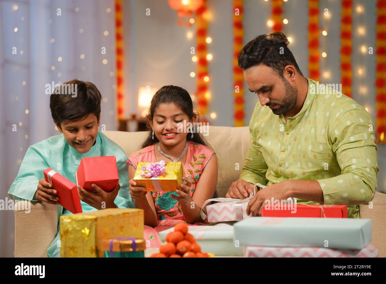 Indian father busy preparing gifts for diwali while spending time with ...