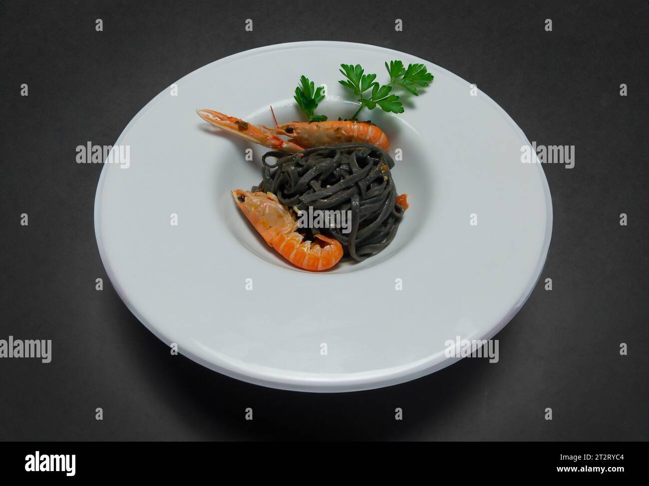 Cuttlefish ink tagliolini with scampi, a typical dish of Italian ...