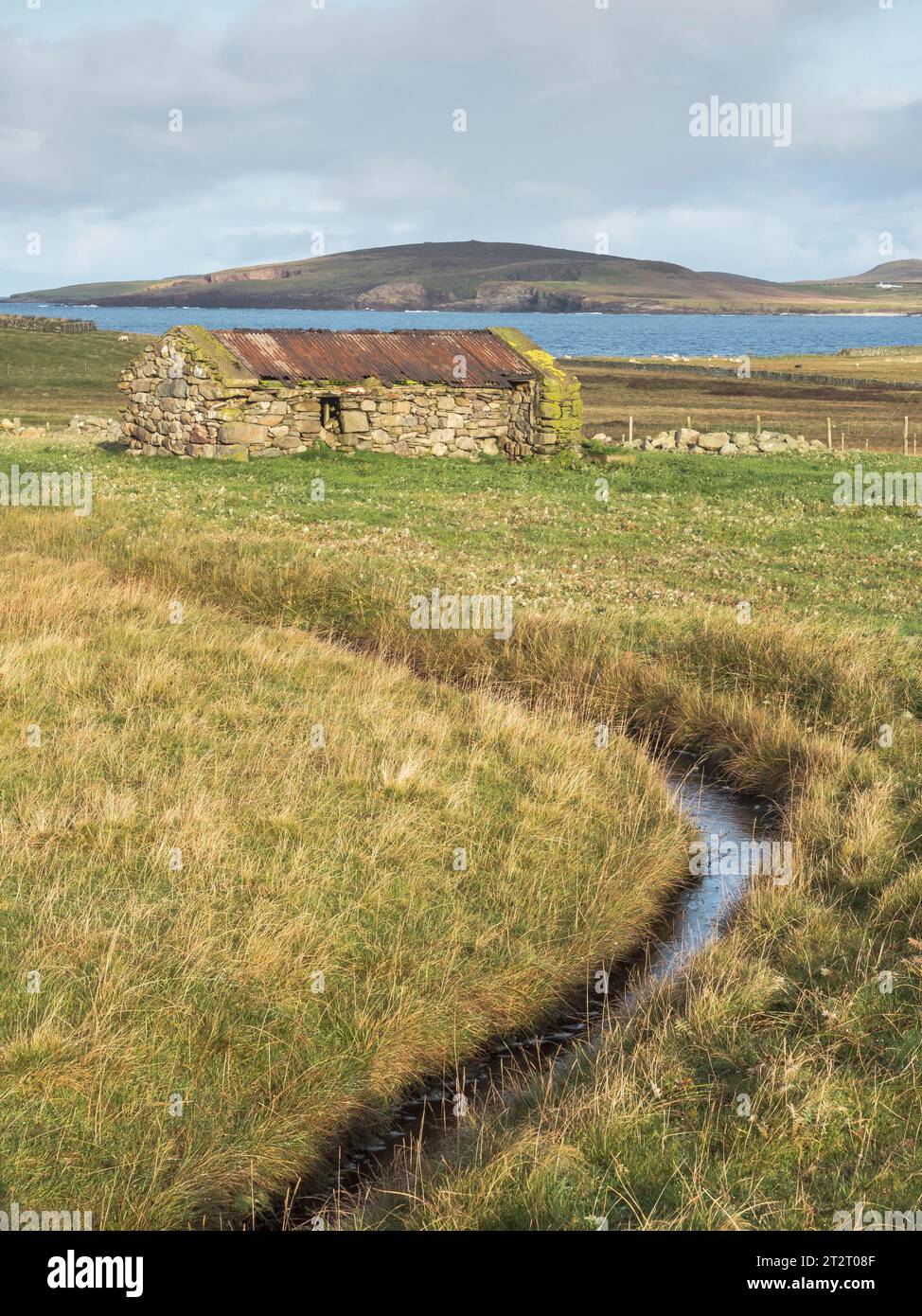 View of old stone farm building and ditch, near Melby, with Papa Stour ...