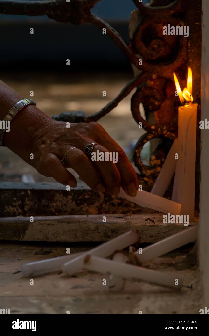 Candles being lit by a human hand. Religious request concept. yellow ...