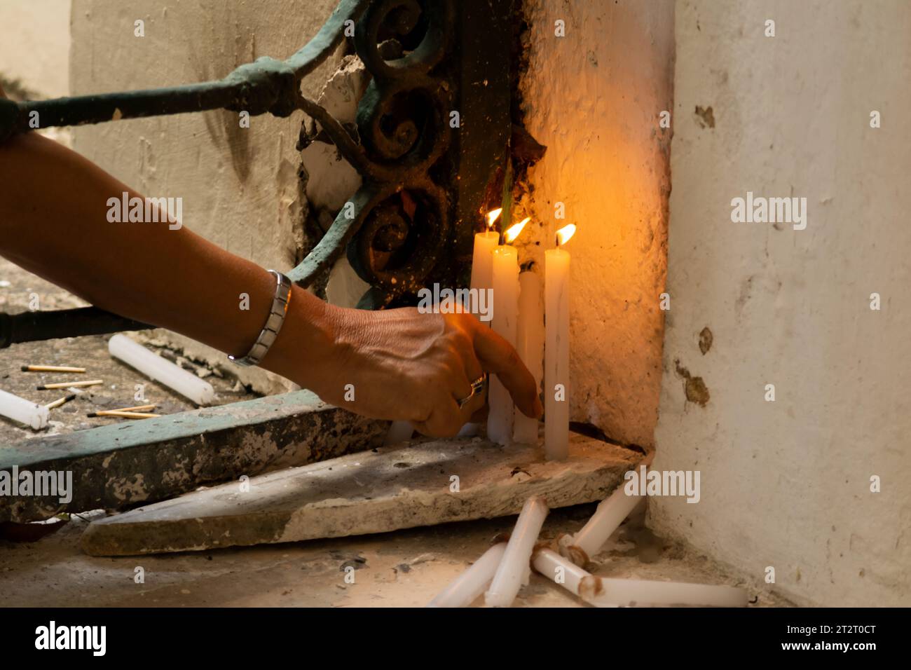 Candles being lit by a human hand. Religious request concept. yellow ...