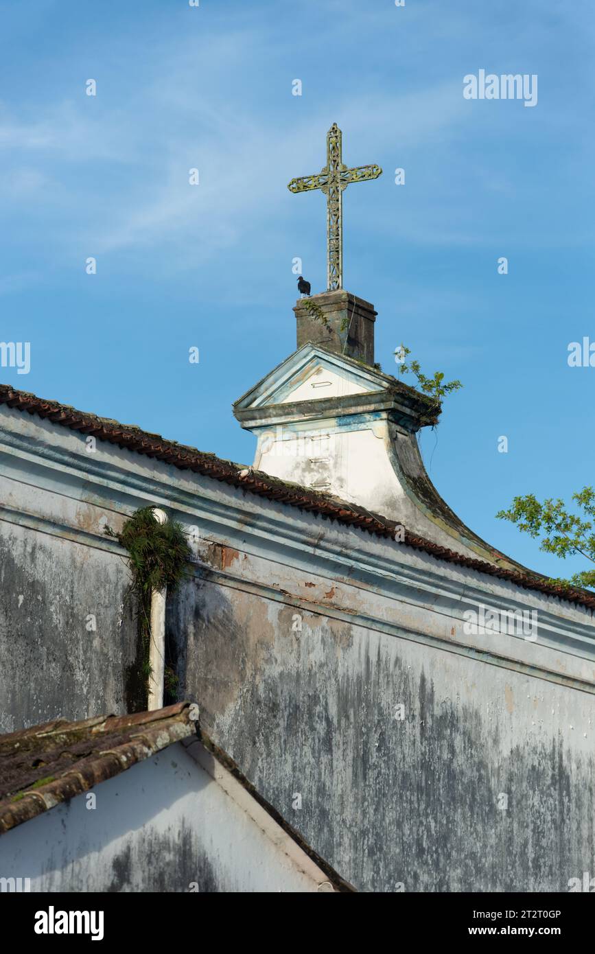 A black vulture standing beneath the cross of an old church. Abandoned ...