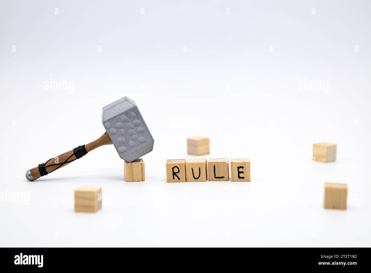 The wooden cubes with the word RULE and the weapon around against white ...