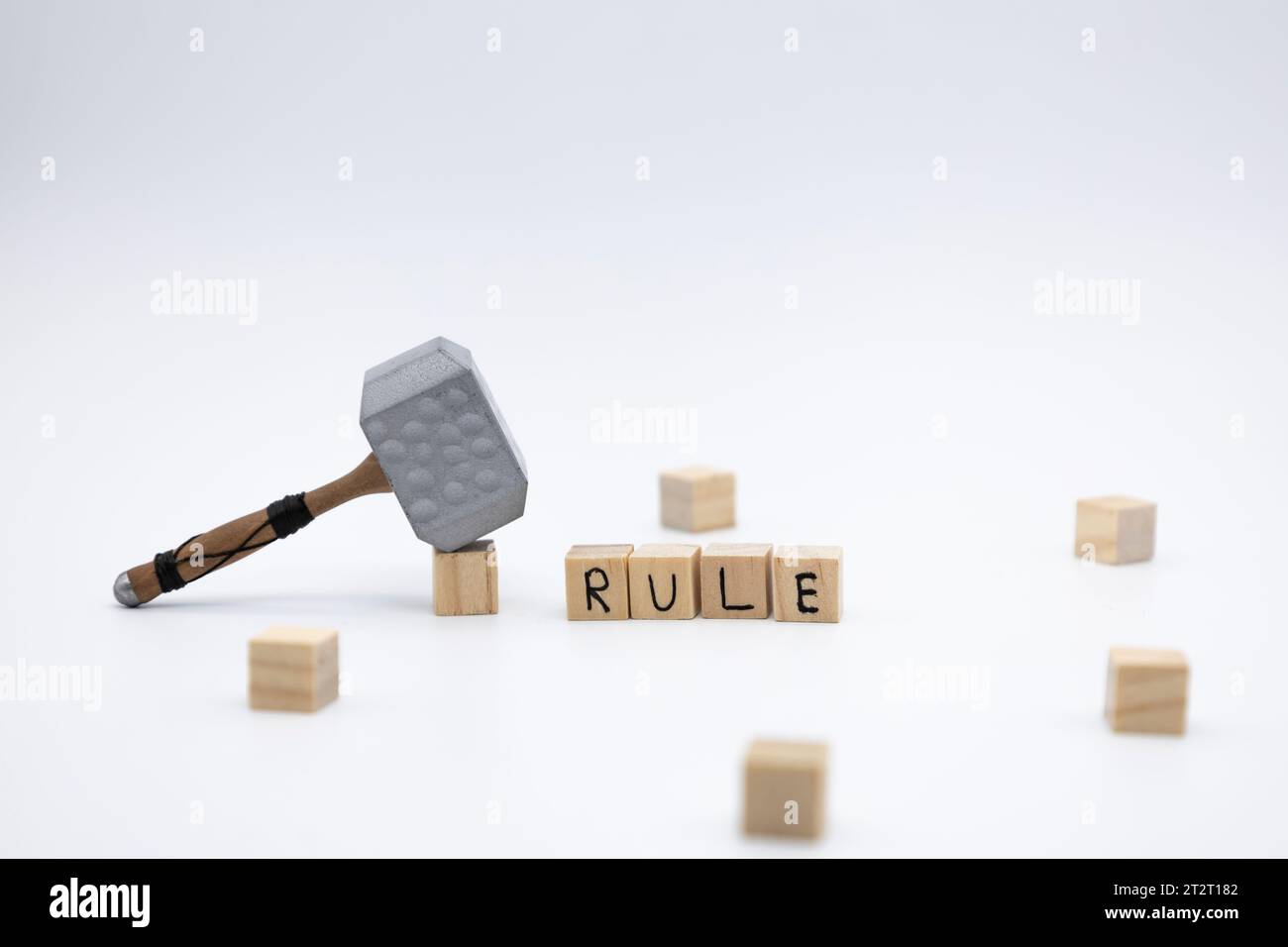 The wooden cubes with the word RULE and the weapon around against white ...