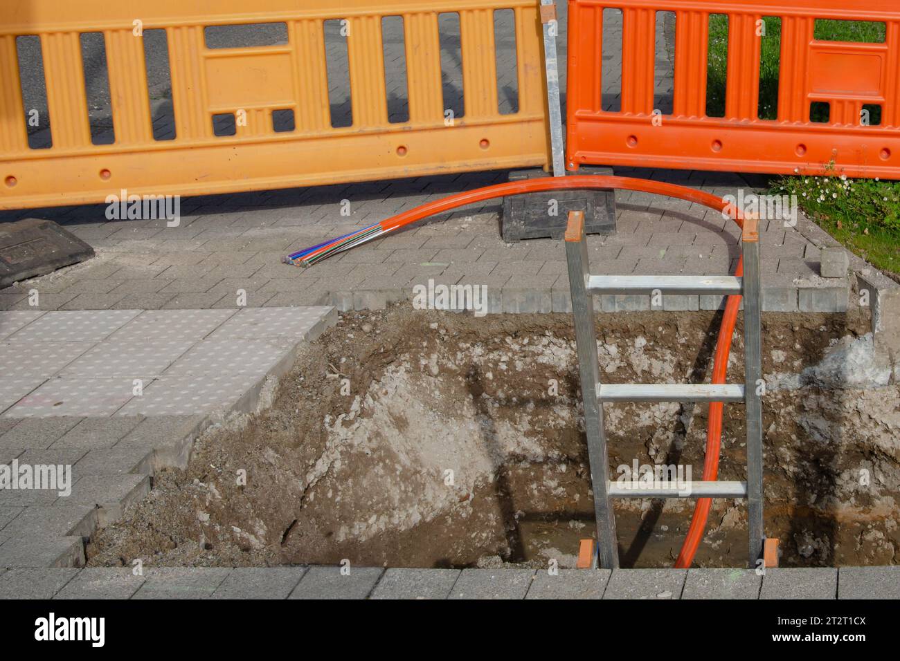 Fibre optic cable installation and ladder in the excavation. Orange ...
