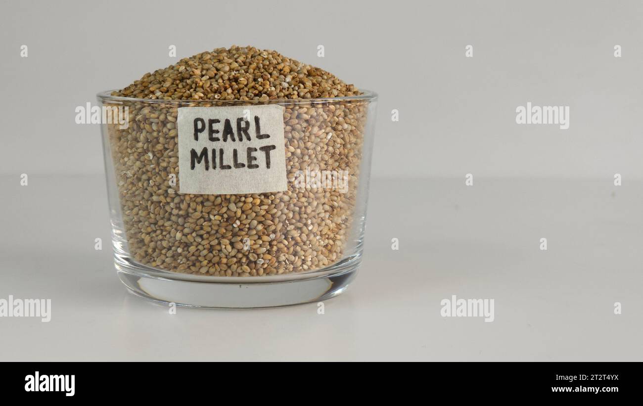 Pearl millet grains in a glass bowl with label on it filled to the brim ...