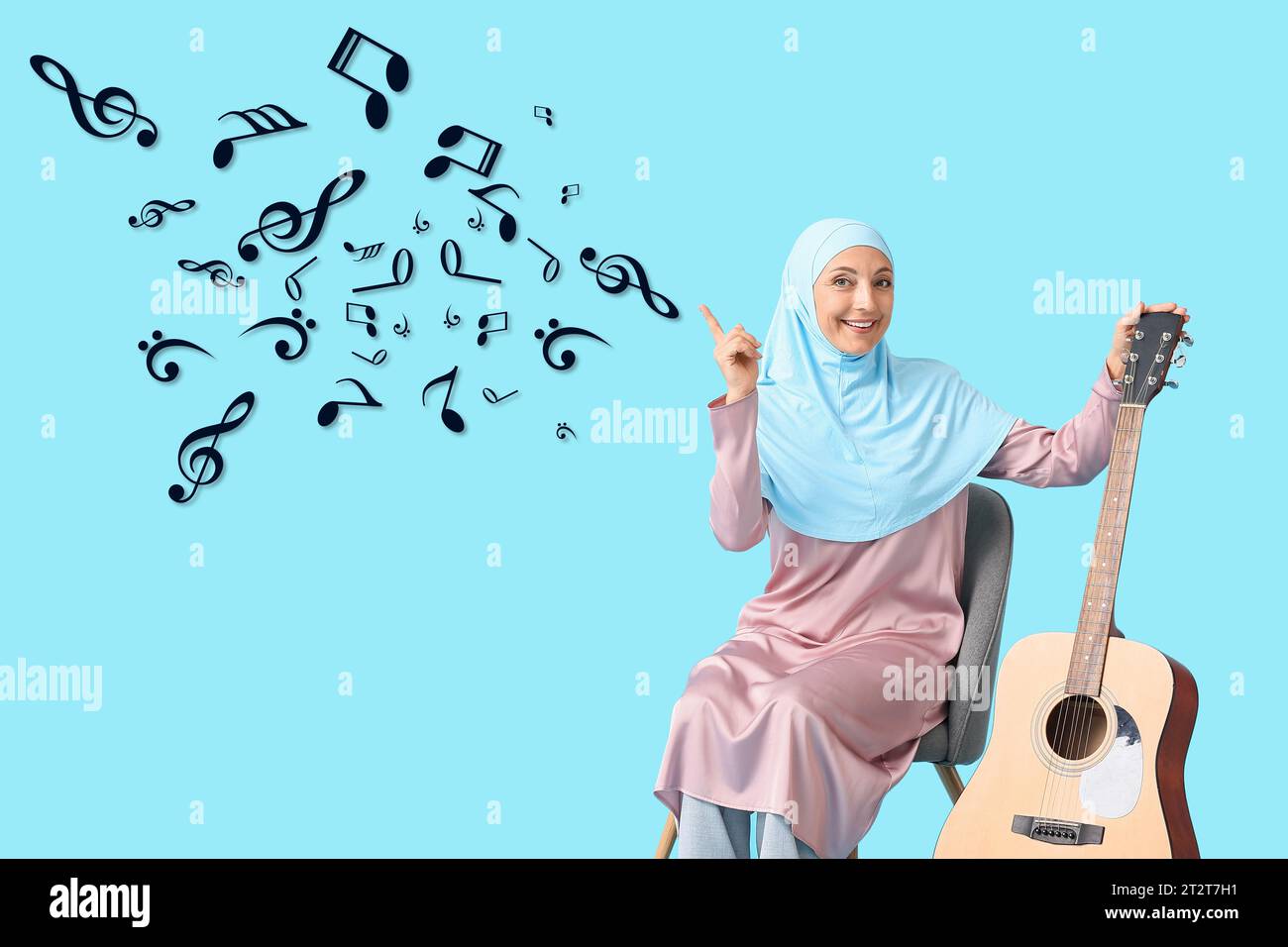 Female Muslim music teacher with guitar on light blue background Stock ...