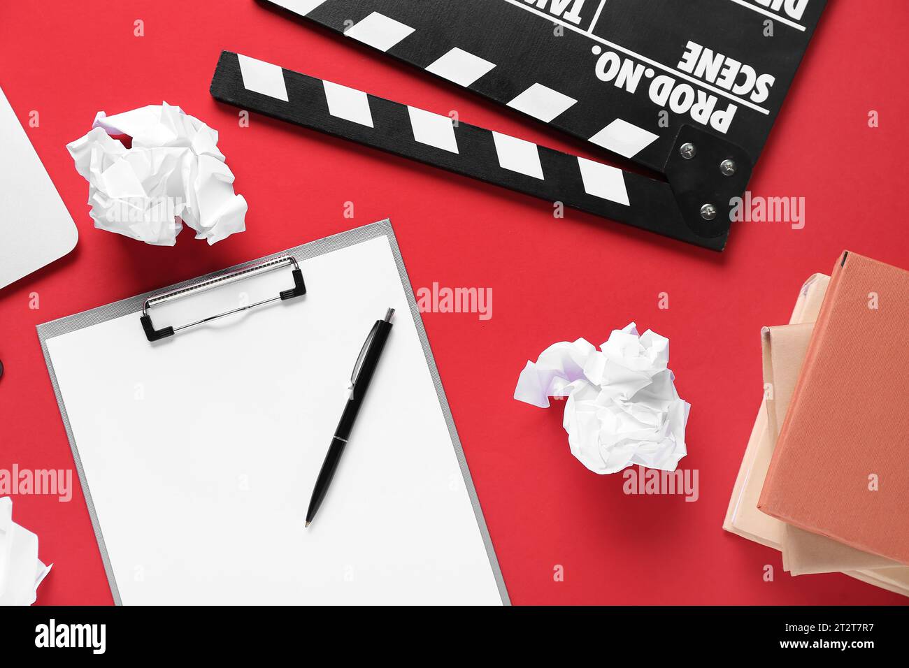 Clipboard with crumpled paper, books and movie clapper on red ...