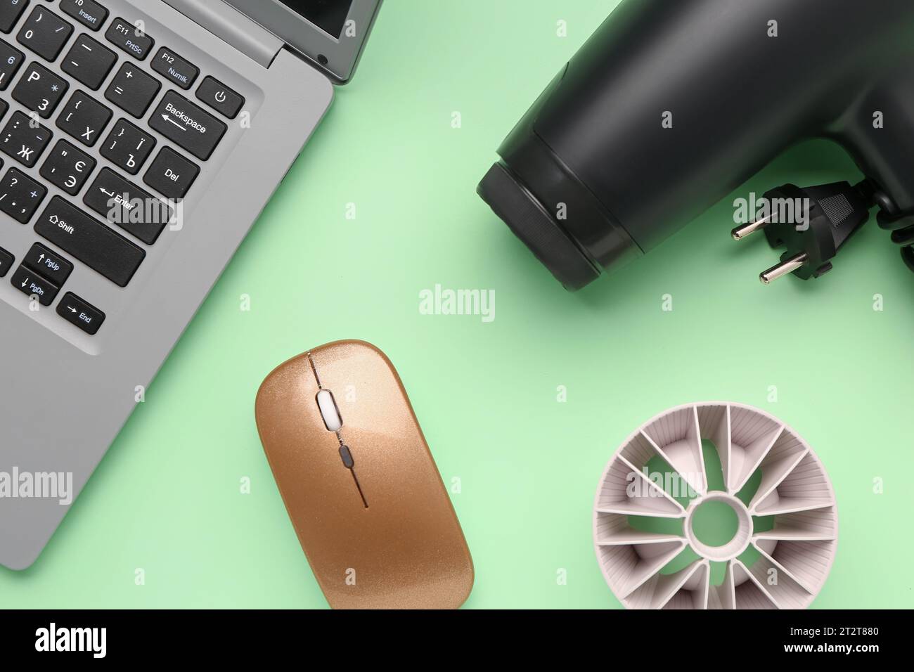 Laptop with computer mouse and hair dryer on green background Stock ...