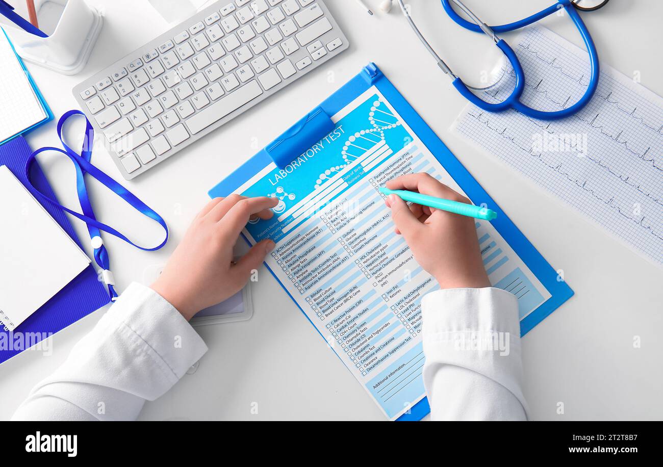Female doctor filling out laboratory test on white medical desk, top ...
