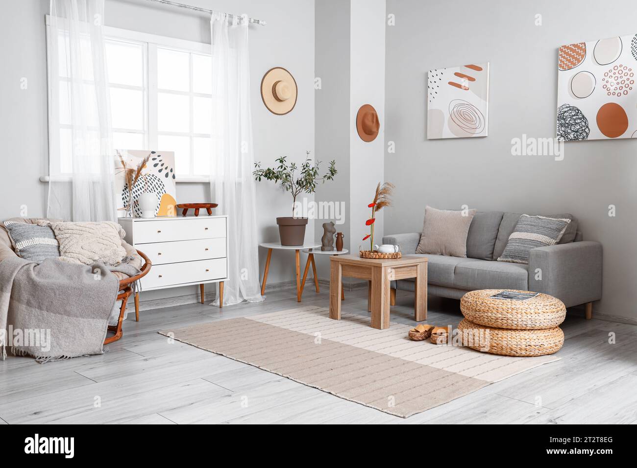 Interior of living room with beautiful ikebana and sofa Stock Photo - Alamy
