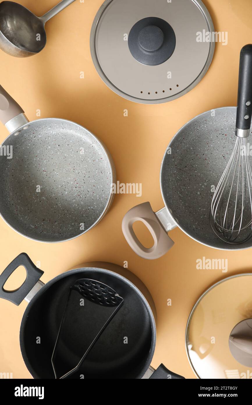 Cooking pots and kitchen utensils on beige background Stock Photo - Alamy