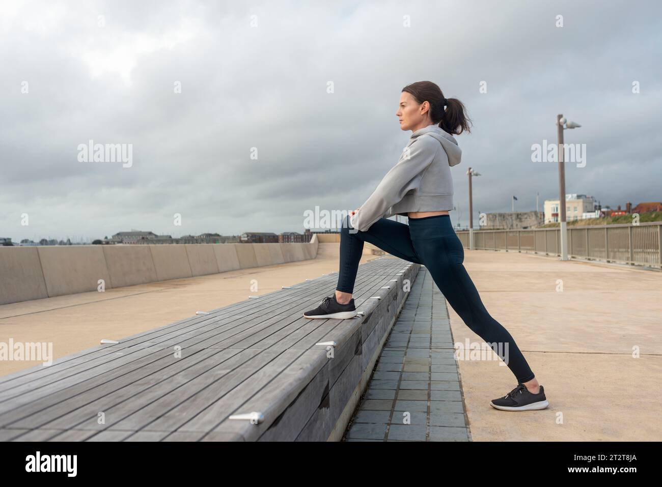 Sporty woman doing leg stretching exercises, outside. Outdoor workout ...