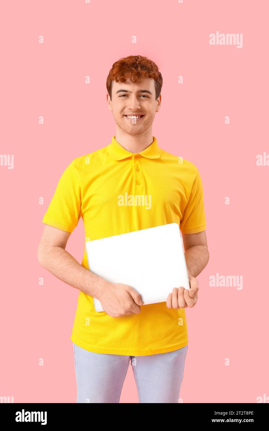 Male programmer with laptop on pink background Stock Photo - Alamy