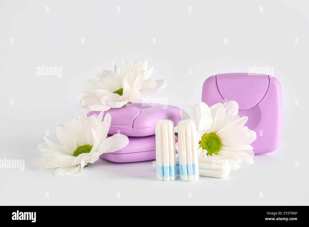 Menstrual tampons, storage boxes and chamomile flowers on white ...