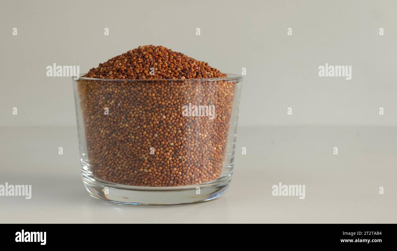 Closeup of finger millet grains kept in a glass bowl filled to the brim ...