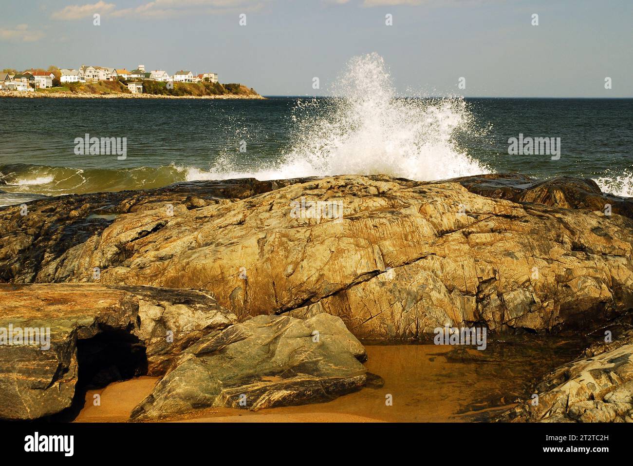 High waves crash into a rocky shore on the beach in New England Stock ...