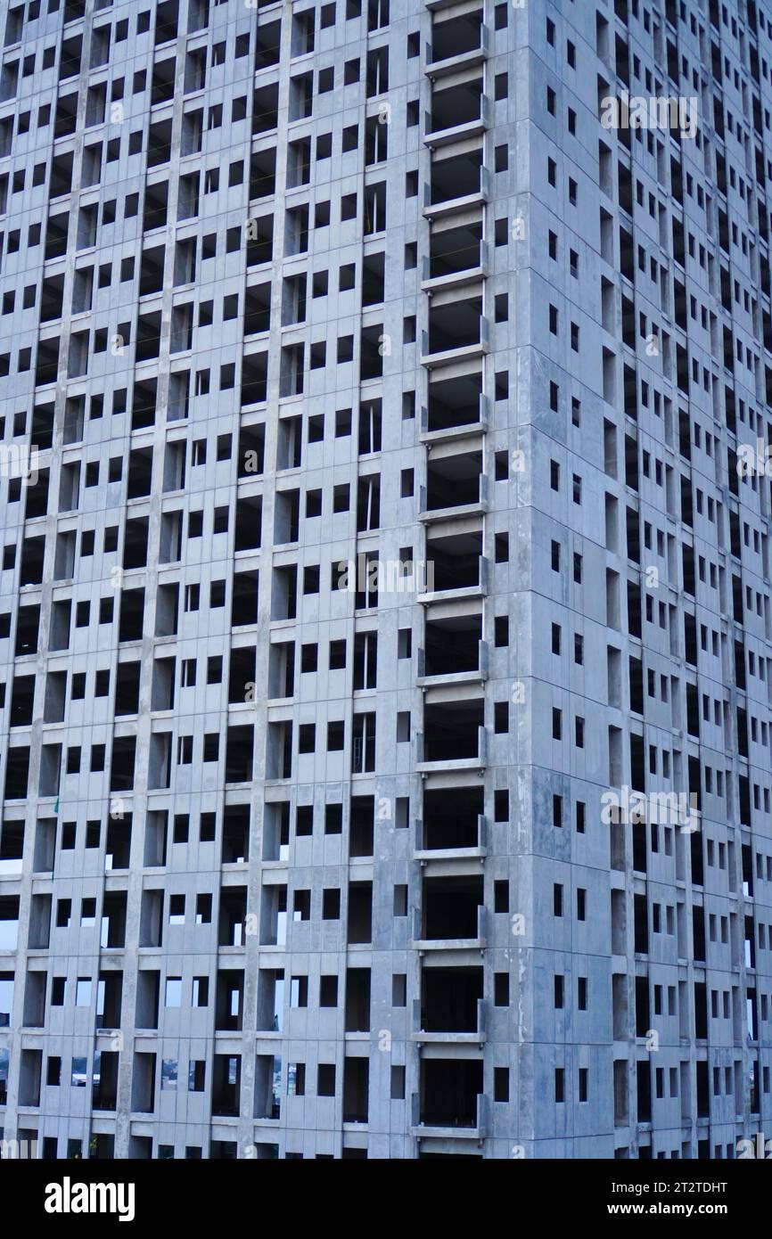 An unfinished building stands tall against a bleak grey sky, devoid of ...