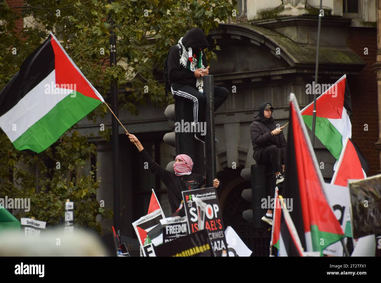 London, England, UK. 21st Oct, 2023. Protesters climb on traffic lights ...