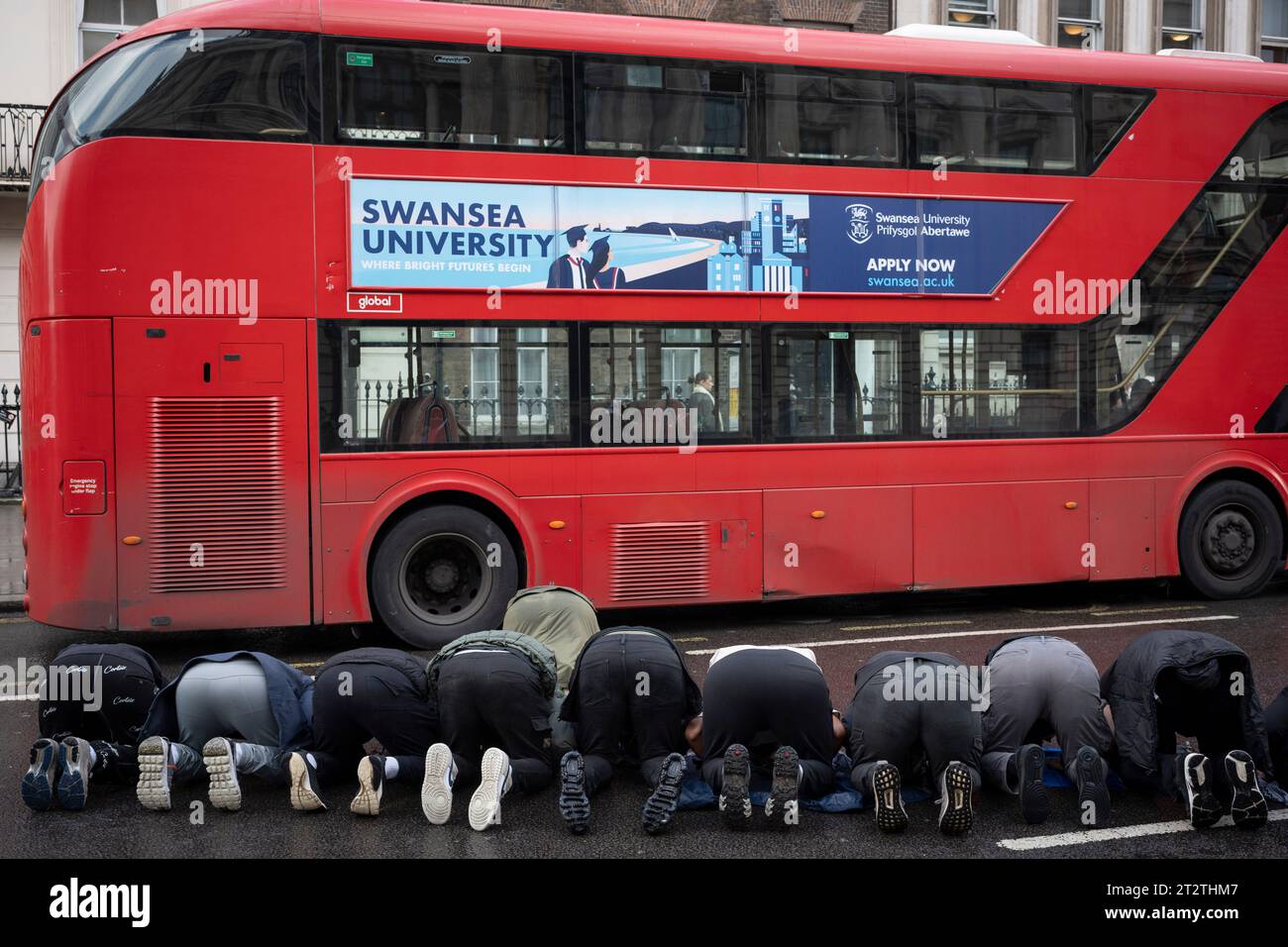 Muslim men pray next to a London bus as pro-Palestinian protesters ...