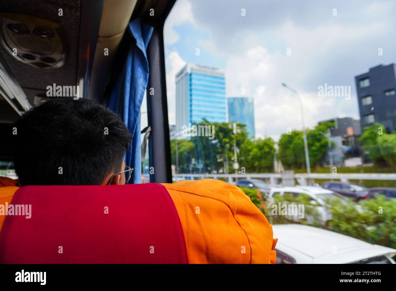 Looking out the window of a moving bus, a man is captivated by the ...