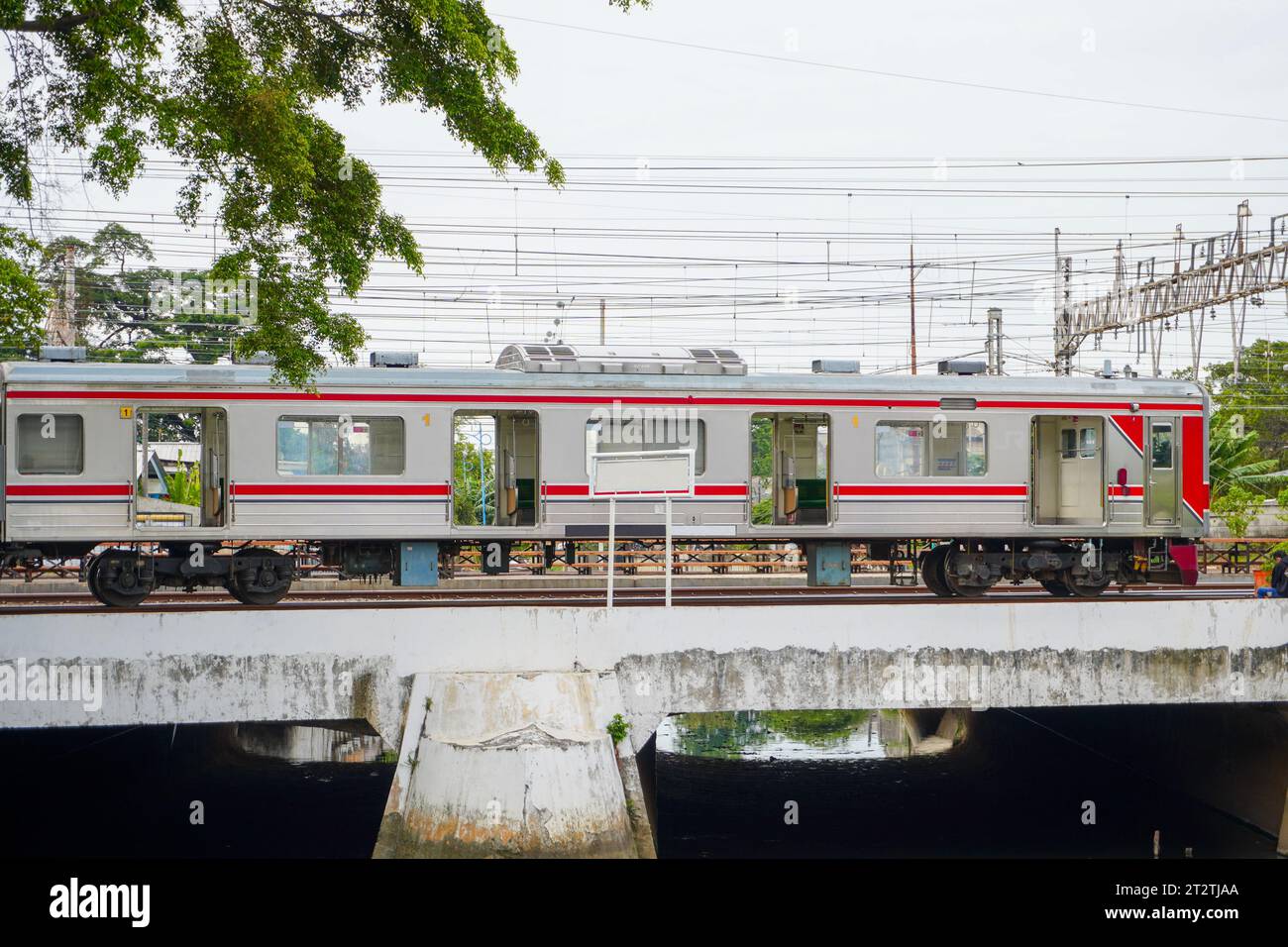 Passenger train without passengers passing over a railroad bridge Stock ...
