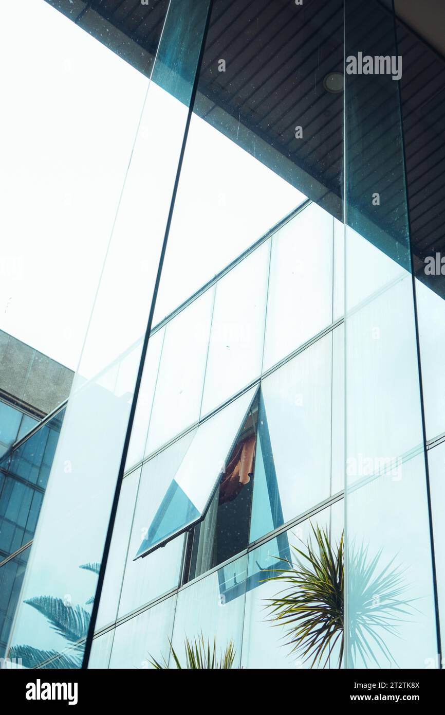 Mesmerizing low-angle glimpse: an open high-rise window revealing a ...