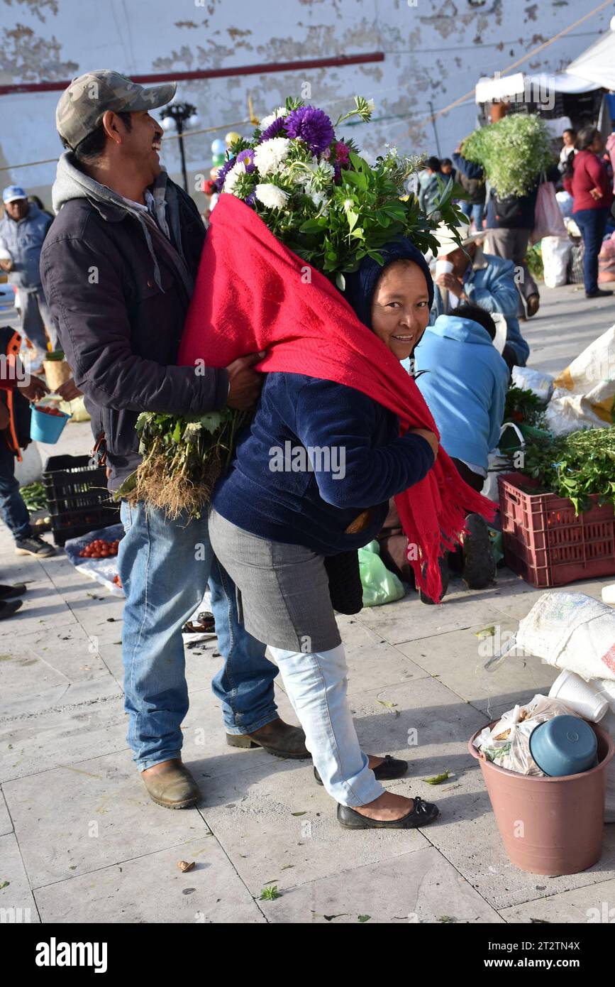 Woman carrying day of the dead flowers on her back hi-res stock ...